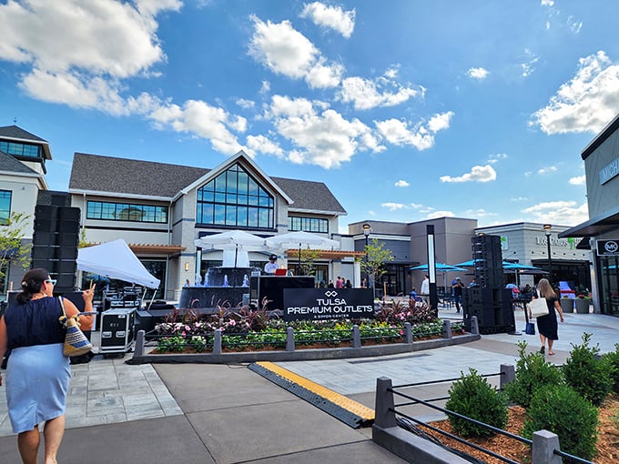 The central plaza at Tulsa Premium Outlets basks under Oklahoma's impossibly blue sky&mdash;a retail oasis where shopping bags multiply faster than clouds on the horizon.