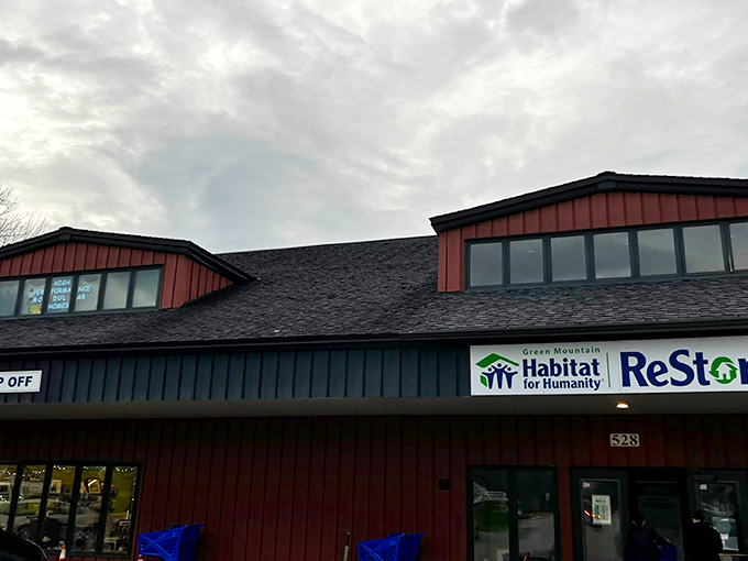 The familiar red siding of the Habitat ReStore in Williston stands tall beneath a moody Vermont sky, inviting shoppers in search of hidden gems and everyday bargains.