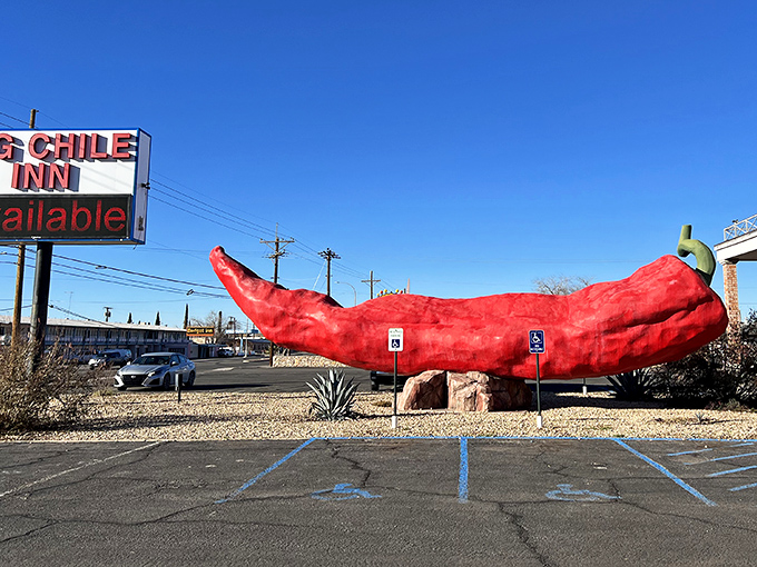 The World's Largest Chile Pepper stretches toward the sky, a fiery red monument to New Mexico's spicy obsession against the perfect blue desert backdrop.