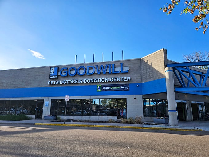 The iconic blue stripe of Aurora's Goodwill beckons like a retail lighthouse, guiding bargain hunters to shores filled with unexpected treasures.