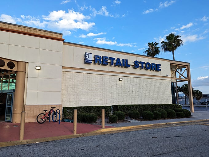 The unassuming exterior of Goodwill on Orange Blossom Trail hides a treasure trove within. Florida's palm trees stand guard over bargain paradise.