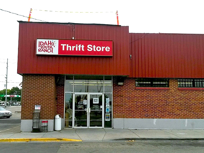 The red-bricked facade of Idaho Youth Ranch Thrift Store stands like a beacon of bargain possibilities, promising treasures within those glass doors.