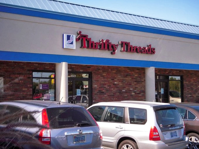 The iconic blue-trimmed storefront of Thrifty Threads stands ready to welcome bargain hunters and treasure seekers alike. Behind these brick walls, fashion finds await their second chance at greatness.