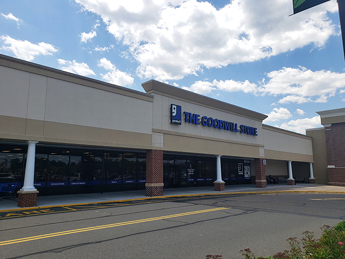The blue Goodwill sign shines like a beacon for treasure hunters under New Jersey skies, promising adventures in secondhand shopping.