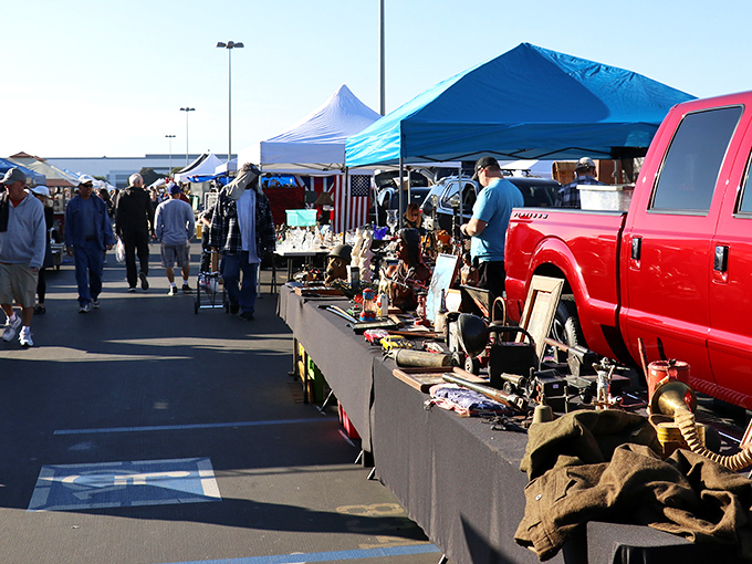Early birds catch the deals! Morning shoppers browse tables laden with curiosities while vendors showcase their wares beside a classic red pickup truck.