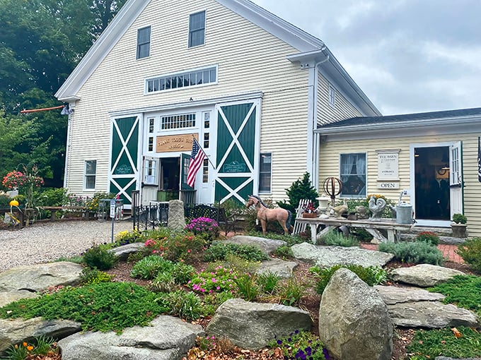 The classic New England charm of Todd Farm's white barn welcomes treasure hunters every Sunday, promising adventures in antiquing beneath those iconic green doors.