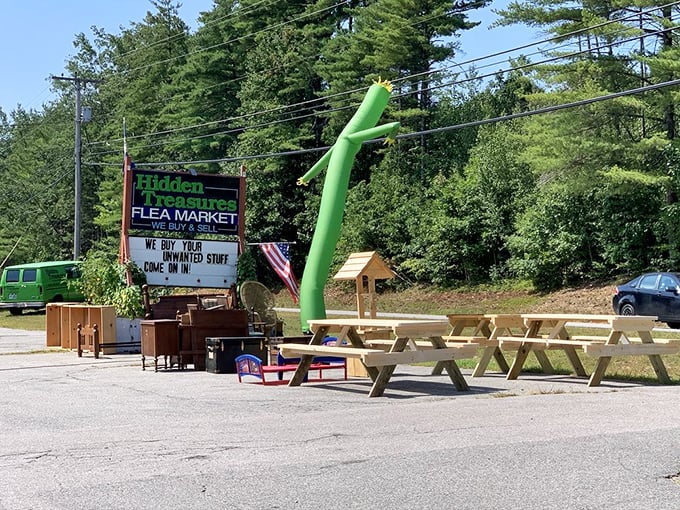 The iconic green tube man waves frantically, as if saying, "Hurry up! All the good stuff's getting snatched inside!" A quintessential New Hampshire treasure hunt awaits.