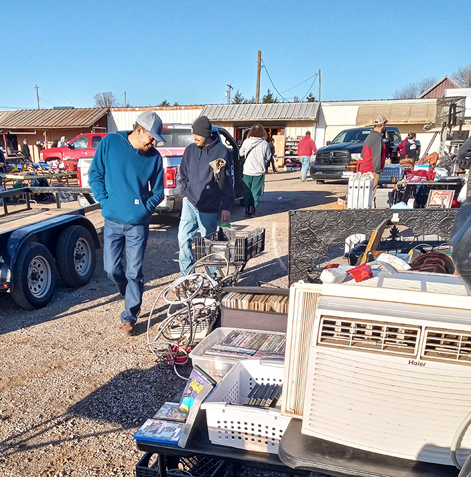 Treasure hunters examine electronics and household items while the Oklahoma sun bathes this corner of bargain paradise in golden light.