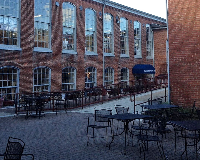 The historic brick facade of Savage Mill welcomes treasure hunters with its imposing windows and outdoor seating area&mdash;industrial chic meets shopping paradise.