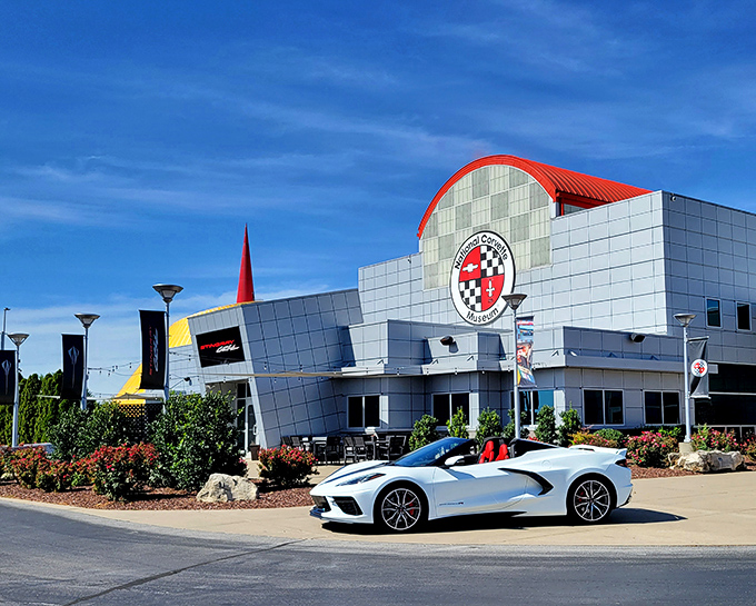 The sleek, modern exterior of the National Corvette Museum stands like a spaceship that landed in Kentucky, complete with its signature red spire reaching skyward.