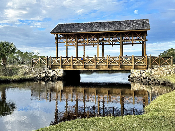 The Princess Place Covered Bridge creates a perfect reflection in the still waters below, like nature's own Instagram filter working its magic.
