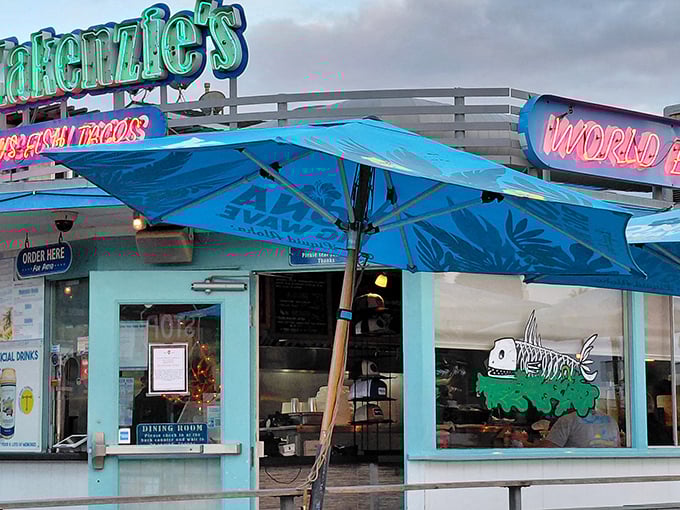 The turquoise beacon of taco paradise beckons hungry travelers with its neon promise of "World Famous Fish Tacos." No false advertising here.