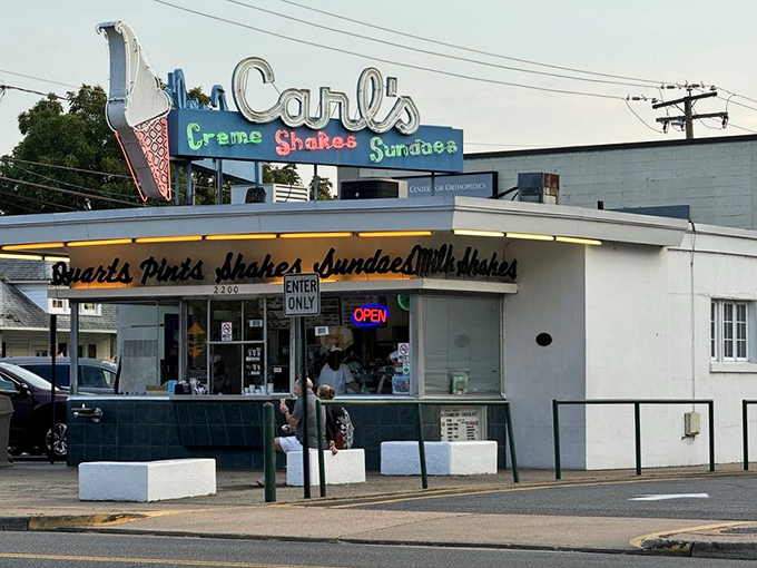 The neon glow of Carl's iconic sign beckons dessert pilgrims like a frozen custard lighthouse on Princess Anne Street. Where sweet dreams are served with a side of nostalgia.