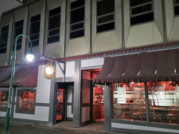 F Street Station's nighttime glow beckons like a lighthouse for hungry souls wandering downtown Anchorage. The red awning and warm lights promise comfort on even the chilliest Alaskan evening.
