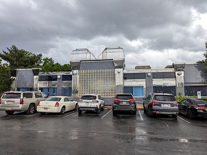 Even under moody skies, this architectural time capsule beckons with the silent promise of comfort food that transcends the ordinary diner experience.