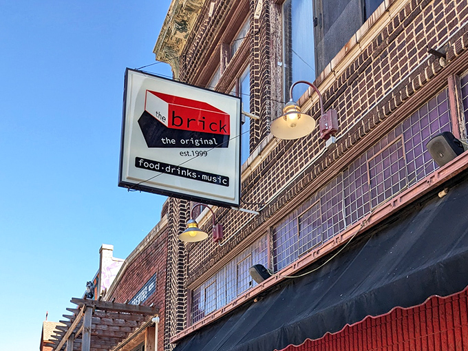 The iconic red and black sign of The Brick stands as a beacon for comfort food seekers in Kansas City's Crossroads Arts District.