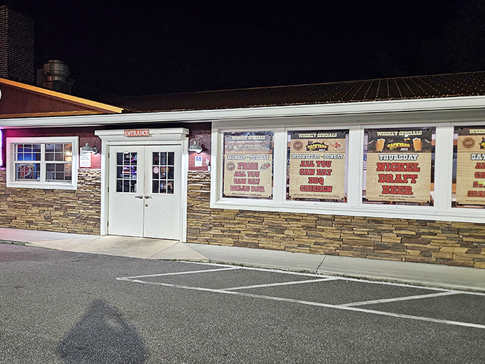 The unassuming stone exterior of Backyard Boys BBQ showcases their weekly specials, promising delicious treasures inside this South Daytona gem.
