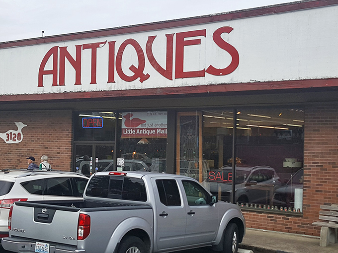 The siren call of vintage treasures beckons from this unassuming storefront. That bold red "ANTIQUES" sign might as well say "ADVENTURE AWAITS."