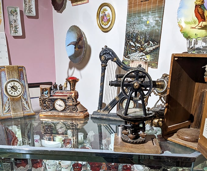 A miniature locomotive clock and antique harp-like device share space behind glass, like time travelers waiting patiently for their next adventure.