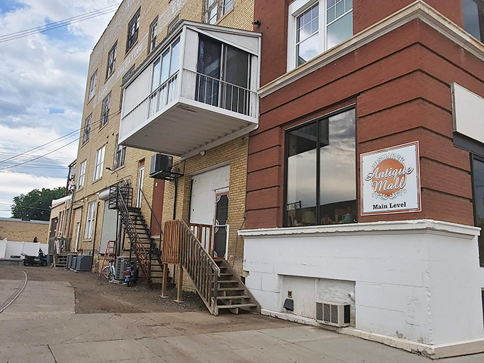 The red-brick exterior welcomes you with its windows and inviting staircase, hinting at the treasure trove waiting inside.