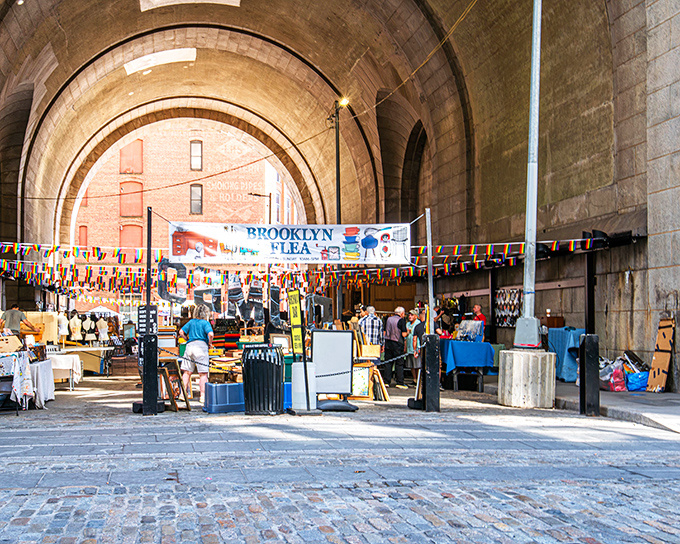 The magnificent archway of the Manhattan Bridge frames Brooklyn Flea like a portal to treasure-hunting heaven. Cobblestones underfoot, bargains ahead!