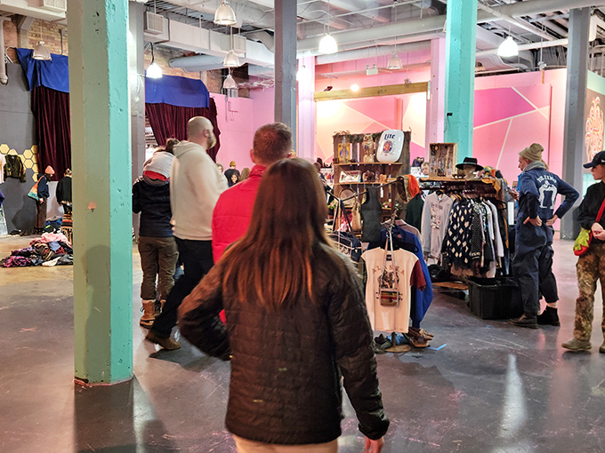 The Urban Flea Market's vibrant interior buzzes with treasure hunters navigating a sea of potential finds under mint-green pillars and playful pink walls.