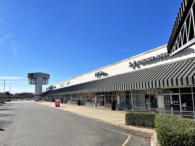 The Under Armour storefront beckons like a siren song to bargain hunters. Blue skies above promise good fortune for those brave enough to venture inside.