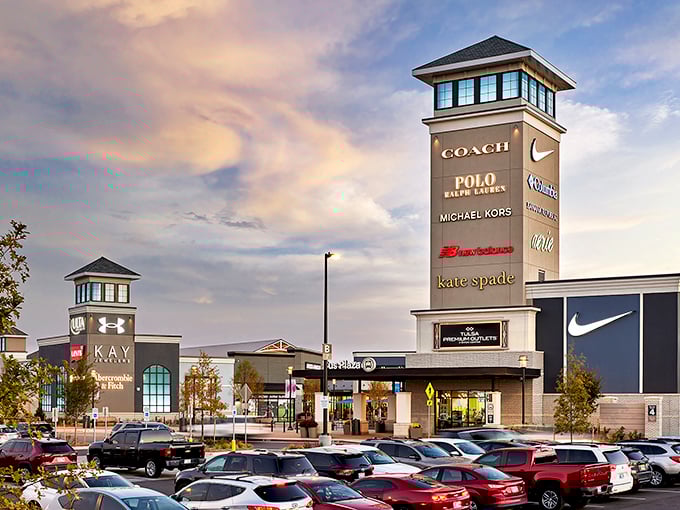 The towering sign at Tulsa Premium Outlets stands like a retail lighthouse, beckoning bargain hunters with promises of Coach, Polo, and Nike treasures within.