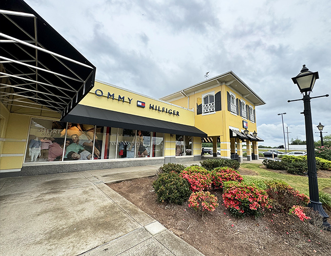 The sunny yellow facade of Tommy Hilfiger welcomes bargain hunters like a beacon of hope for both style and savings.