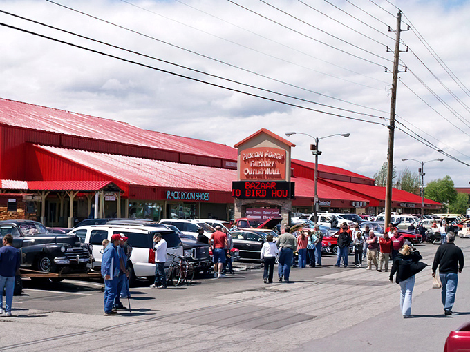 The iconic barn-red facades of Pigeon Forge Factory Outlet Mall stand like beacons of bargain-hunting hope against the Tennessee sky.