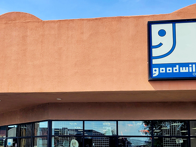 The iconic Goodwill smile greets bargain hunters against the warm adobe backdrop, promising treasures within those New Mexico walls.