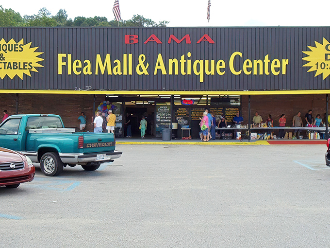The iconic black and yellow storefront of Bama Flea Mall beckons treasure hunters like a siren call to bargain paradise.