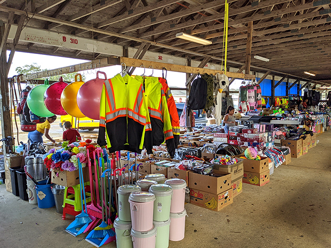 Treasure hunting begins under rustic wooden beams where safety vests hang like neon beacons amid a sea of household treasures and colorful plastic bins.