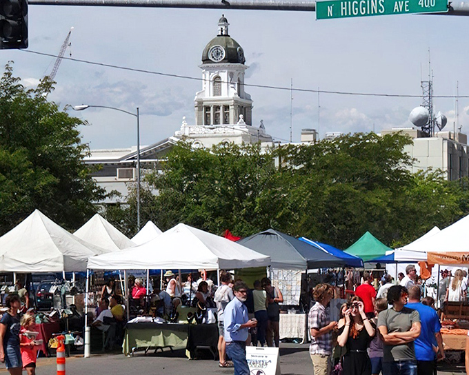 The historic Missoula County Courthouse stands sentinel over a sea of white canopies, where treasures and trinkets await the curious shopper.