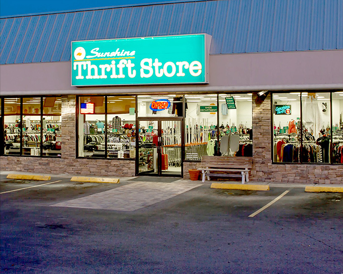 The glowing blue-green sign of Sunshine Thrift Store shines like a beacon in the Florida heat, inviting bargain hunters inside to uncover hidden treasures among its racks.