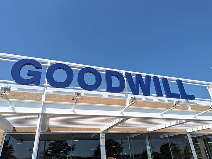 The iconic blue Goodwill sign against a clear Nebraska sky &ndash; where treasure hunting begins and budgets breathe a sigh of relief.