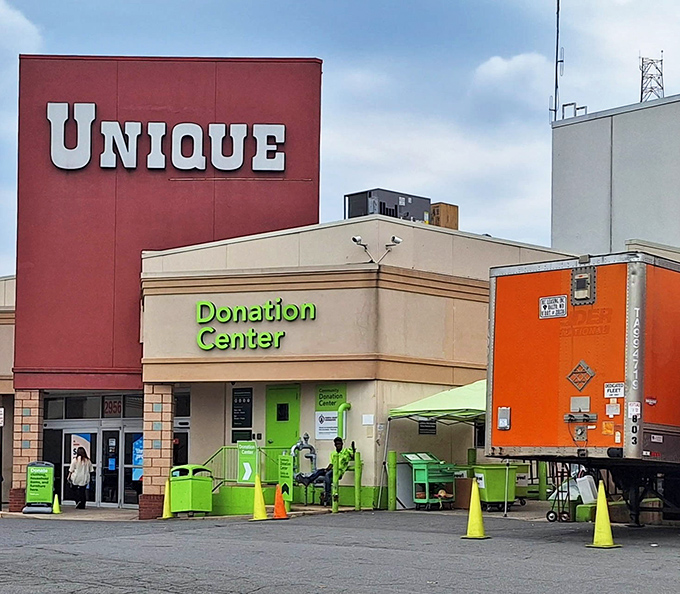 The iconic red sign beckons bargain hunters like a retail lighthouse. Bright green donation bins stand ready to receive yesterday's treasures for tomorrow's discoveries.