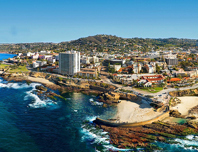La Jolla's coastline unfolds like nature's own IMAX experience, where Mediterranean-style buildings cling to cliffs above impossibly blue waters.