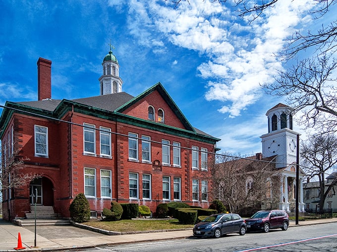 Walley School's stately red brick and white trim exemplify Bristol's architectural heritage, standing sentinel alongside a classic New England church.