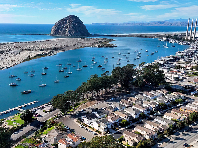 Morro Bay's iconic rock stands sentinel over a harbor dotted with sailboats, like nature's own lighthouse guiding travelers to this coastal haven.