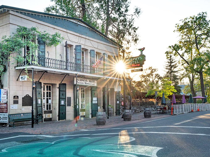 The historic Murphys Hotel basks in golden hour light, a living postcard from the Gold Rush era that's seen more characters than a Dickens novel.