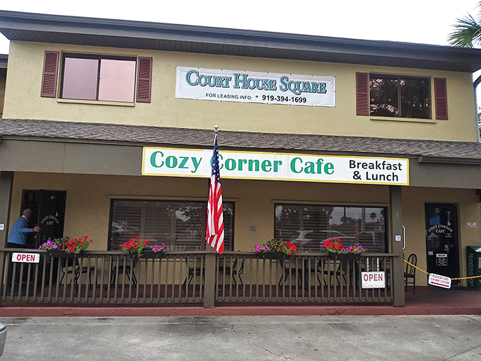 The classic Florida welcome: American flag waving proudly outside Cozy Corner Cafe, where breakfast dreams come true and diet plans go to die happily.