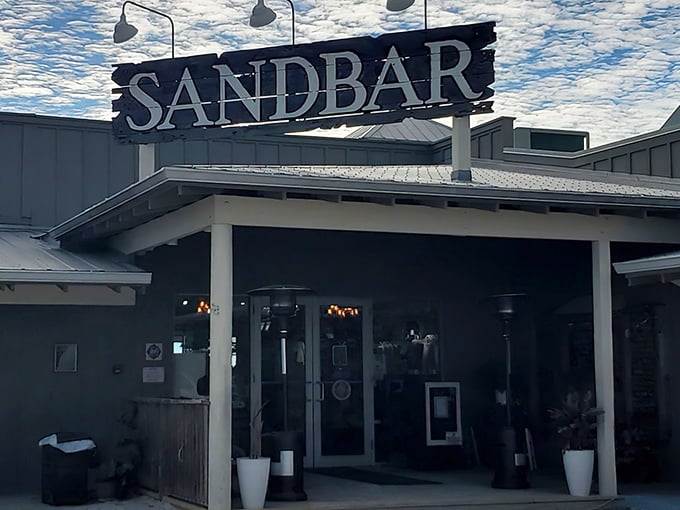 The weathered wooden sign above Sandbar's entrance tells you everything: this isn't fancy Florida, this is authentic Florida—where seafood matters more than scenery.