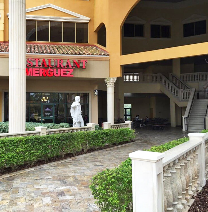 The warm terracotta exterior of Merguez Restaurant stands like a Moroccan oasis amid Orlando's landscape, complete with classical columns and Mediterranean charm.