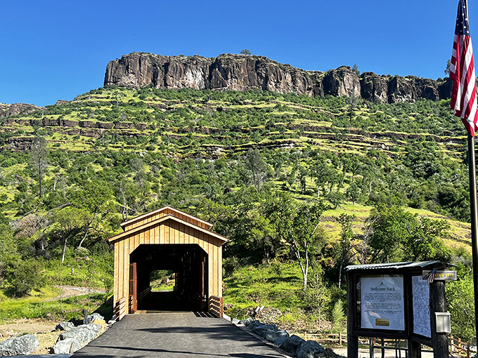 Nestled beneath dramatic cliffs, this wooden time capsule stands guard. The American flag adds a patriotic touch to this quintessentially American architectural treasure.