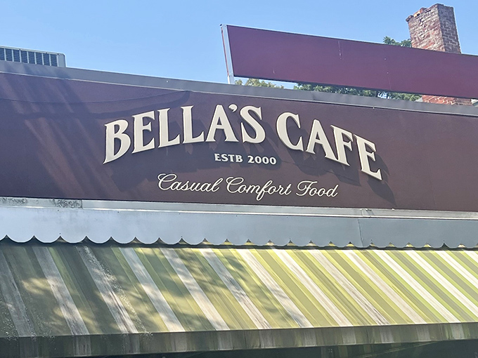 The welcoming storefront of Bella's Cafe in New Haven, where that distinctive burgundy sign and green-striped awning promise comfort food magic within.