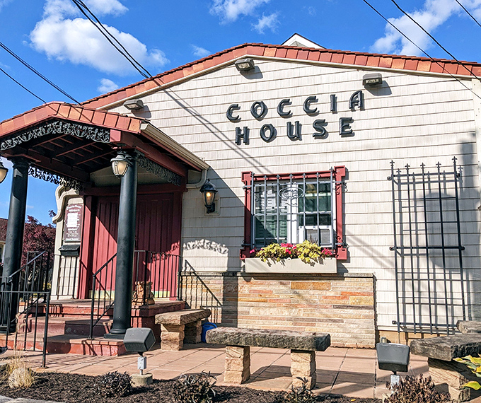 The cottage-like exterior of Coccia House beckons like an old friend, promising comfort food treasures behind that iconic red door.