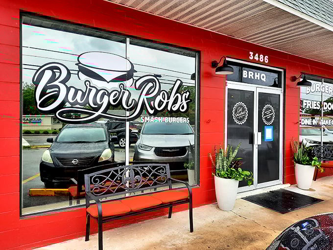 The vibrant red exterior of BurgerRobs beckons burger enthusiasts with its bold signage and welcoming bench—a humble facade hiding extraordinary flavors within.