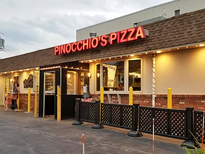 The neon glow of Pinocchio's sign beckons hungry travelers like a lighthouse for the stomach-challenged. No lies about this pizza joint's charm.