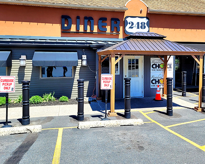 The orange and blue exterior of Diner 248 stands out like a beacon of hope for hungry travelers. Curbside pickup signs promise satisfaction even for those in a hurry.